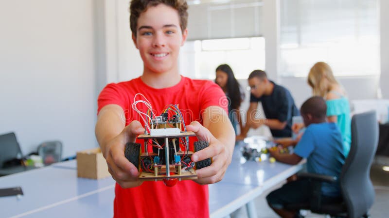 Portrait of Smiling Male Student Holding Robot Vehicle Built in School ...