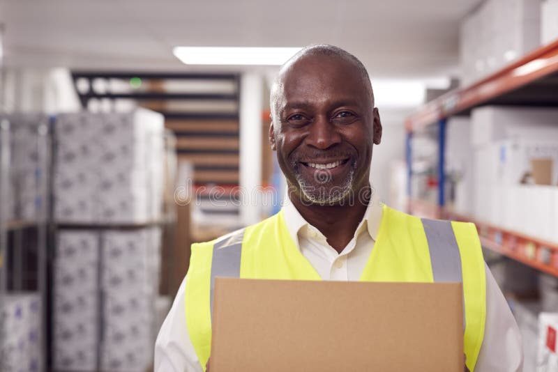 Portrait of Smiling Male Worker Holding Box Inside Warehouse Stock ...