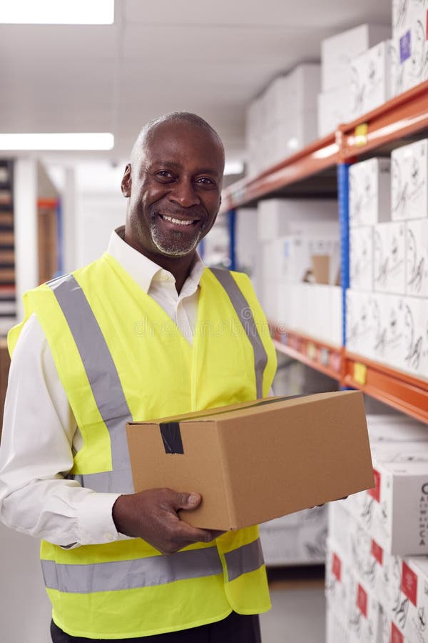 Portrait of Smiling Male Worker Holding Box Inside Warehouse Stock ...