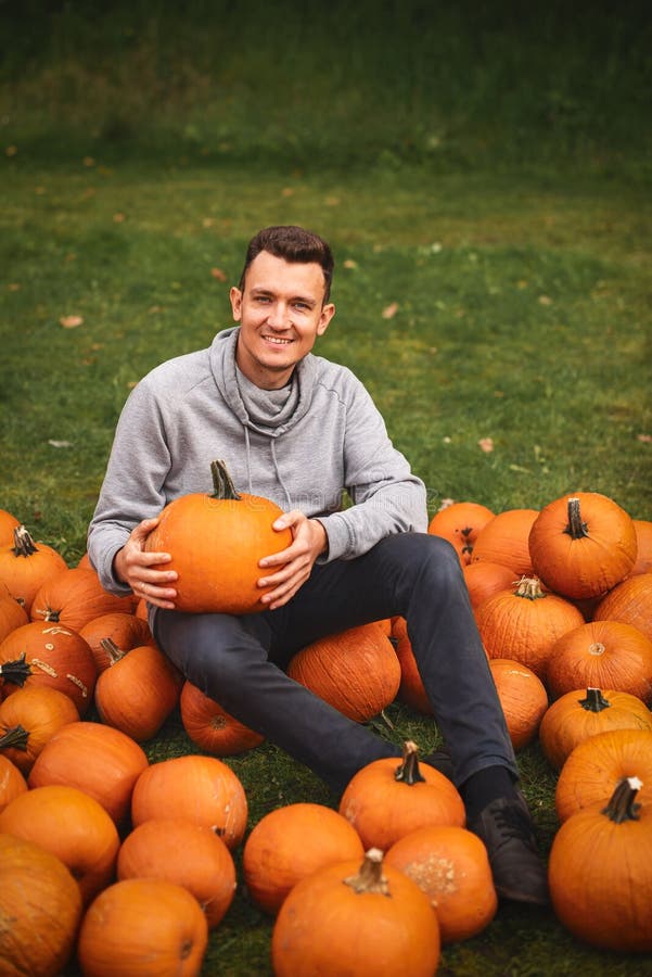 Portrait of Smiling Man Holding Big Pumpkin at Pumpkin Farm Stock Photo ...