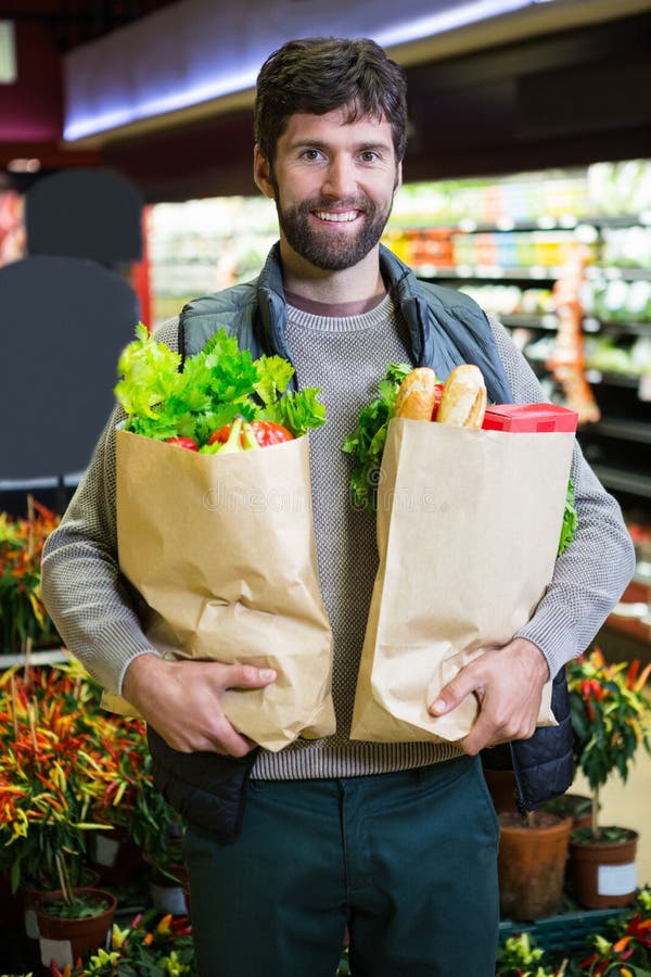 Portrait of Smiling Man Holding a Grocery Bag in Organic Section Stock ... Portrait of Smiling Man Holding a Grocery Bag in Organic Section Stock ...