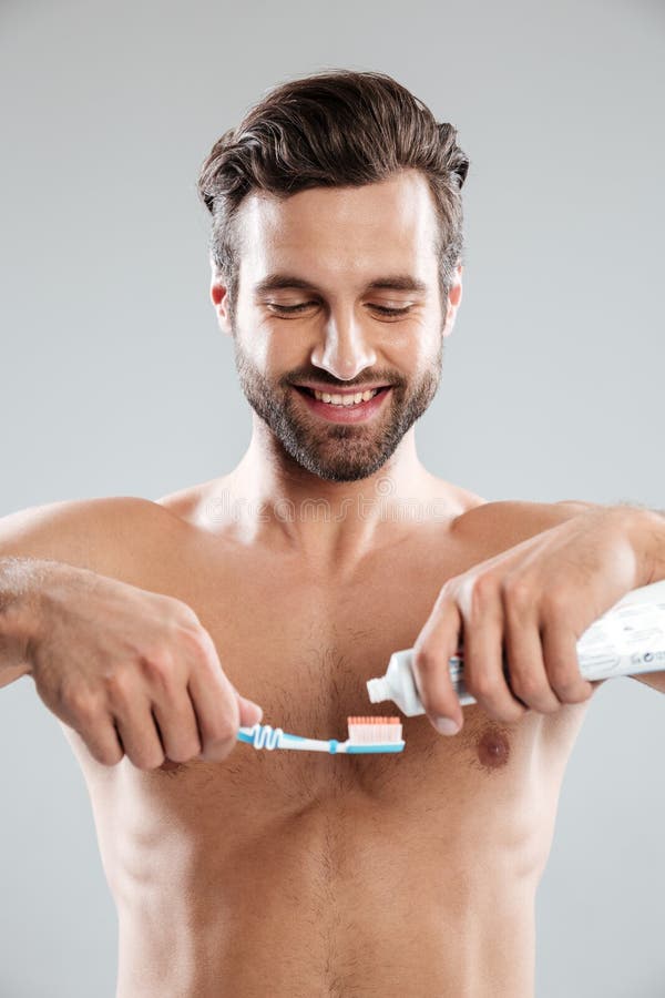 Portrait of a Smiling Man Putting Toothpaste on a Toothbrush Stock ...