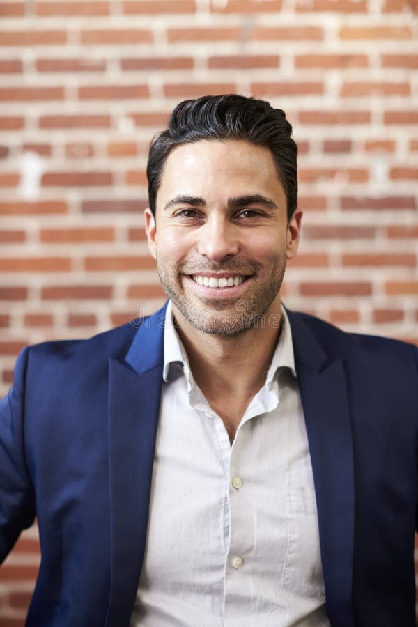 Portrait of Smiling Mature Businessman Standing Against Brick Wall in ... Portrait of Smiling Mature Businessman Standing Against Brick Wall in ...
