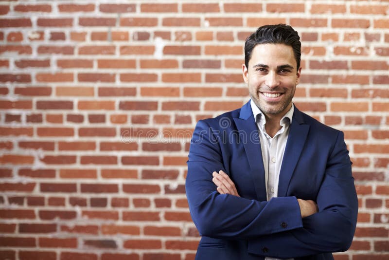 Portrait of Smiling Mature Businessman Standing Against Brick Wall in ... Portrait of Smiling Mature Businessman Standing Against Brick Wall in ...