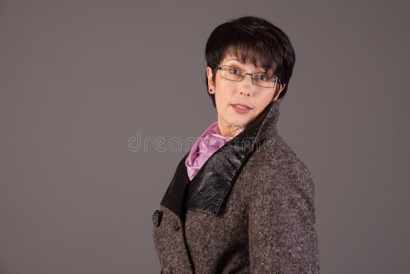 Portrait Of A Smiling Middle Aged Caucasian Woman Against Grey