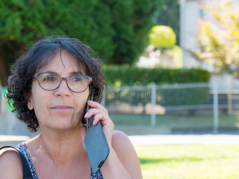 Portrait of a Smiling Middle Aged Woman Using Mobile Phone Outside ...