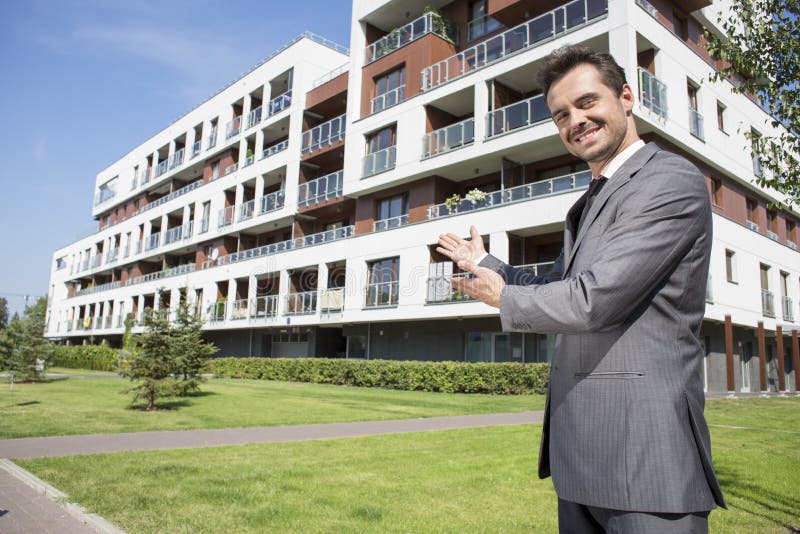Portrait of Smiling Real Estate Agent Presenting Office Building Stock ...