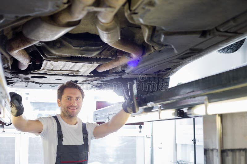Portrait of Smiling Repair Worker Examining Car in Workshop Stock Photo ...