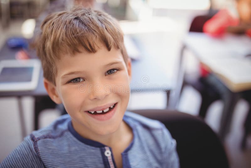 Portrait of Smiling Schoolboy Sitting in Classroom Stock Photo - Image ...