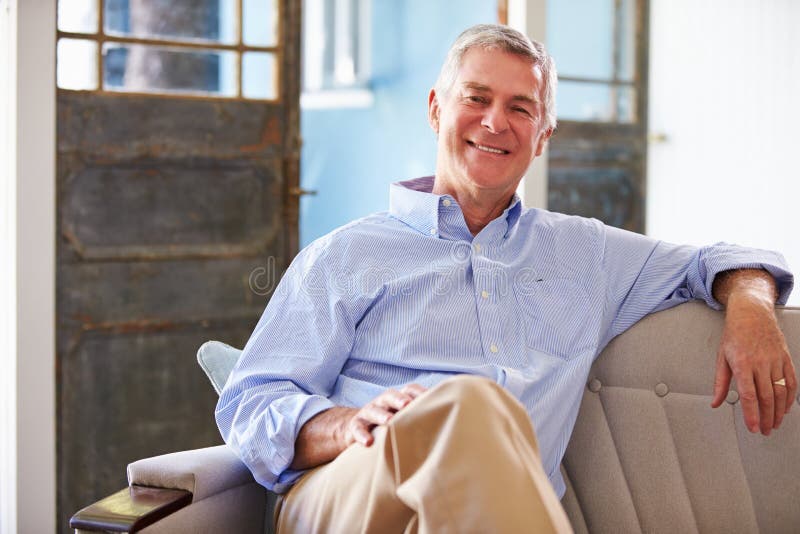 Portrait of Smiling Senior Man Sitting on Sofa at Home Stock Photo ...
