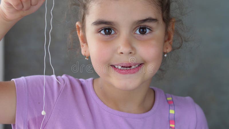 Portrait of a Smiling Toothless Child Holding a Tooth on a String ...