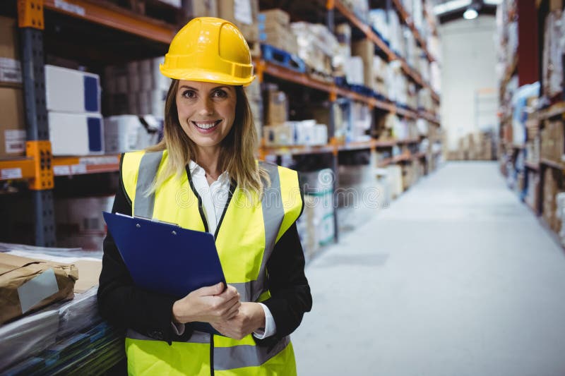 Female Warehouse Supervisor Standing in Aisle Wearing Yellow Safety ...