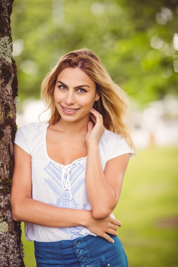 Portrait of Smiling Woman Standing by Tree Stock Image - Image of hair ...