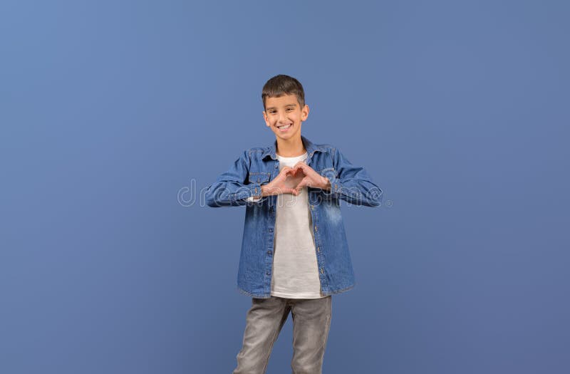 Portrait of Smiling Young Boy Making Heart Shape with Hands while ...