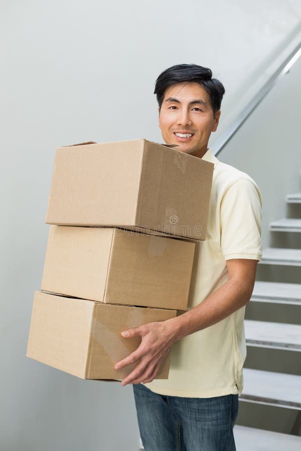 Portrait of a Smiling Young Man Carrying Boxes Stock Photo - Image of ...
