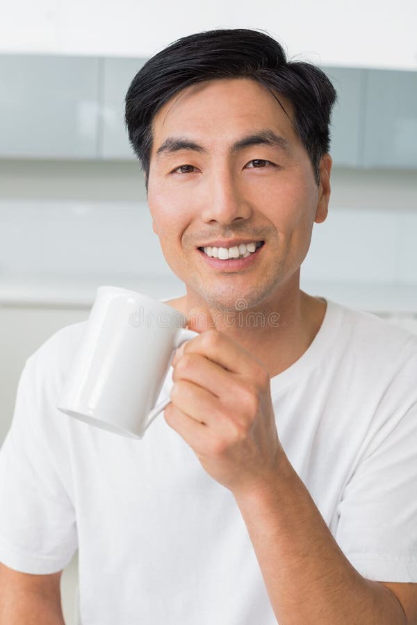 Portrait of a Smiling Young Man Drinking Coffee in Kitchen Stock Photo ...