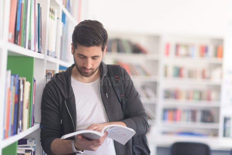 Portrait of Student while Reading Book in School Library Stock Photo ...