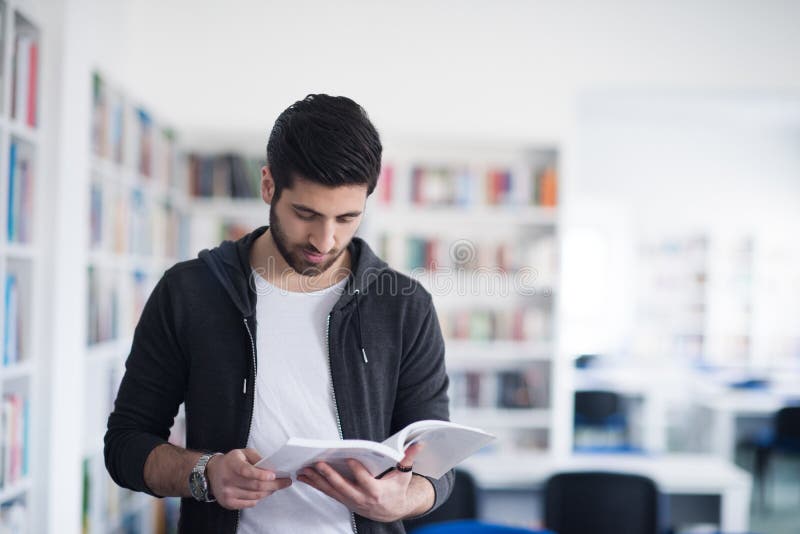 Portrait of Student while Reading Book in School Library Stock Photo ...