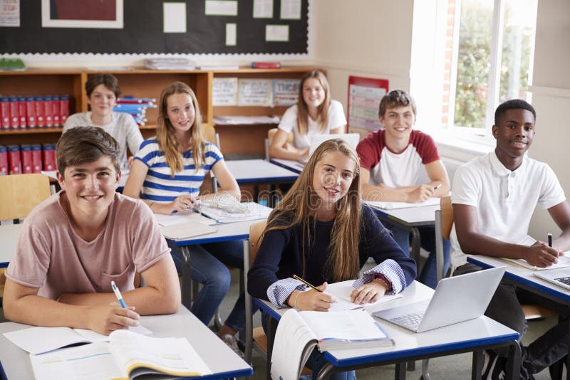 Portrait of Students Sitting at Desks in Classroom Stock Photo - Image ...