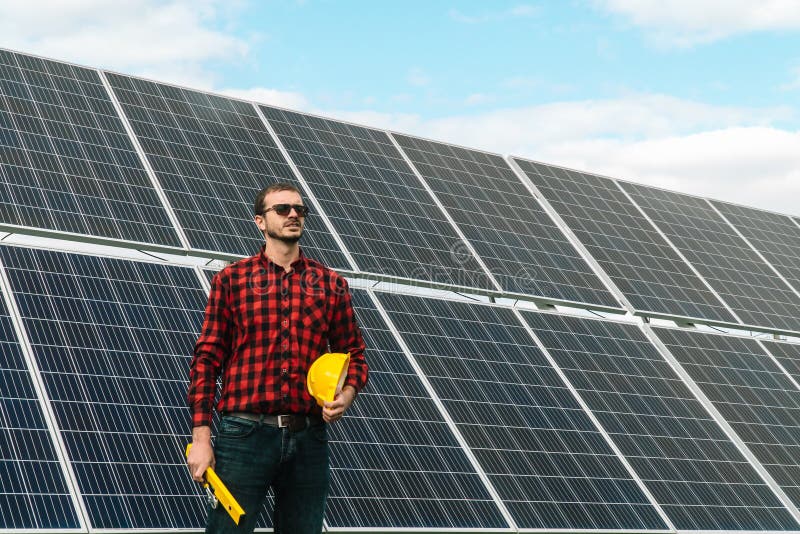 Portrait of a Successful Young Engineer on the Background of a Solar ... Portrait of a Successful Young Engineer on the Background of a Solar ...