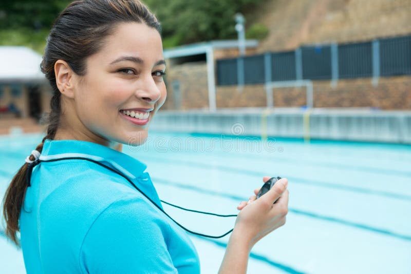 Portrait Of Swim Coach Holding Stopwatch And Showing Thumbs Up Near
