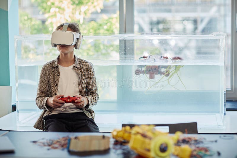 Boy Operating Robot in VR stock photo. Image of design - 254694940