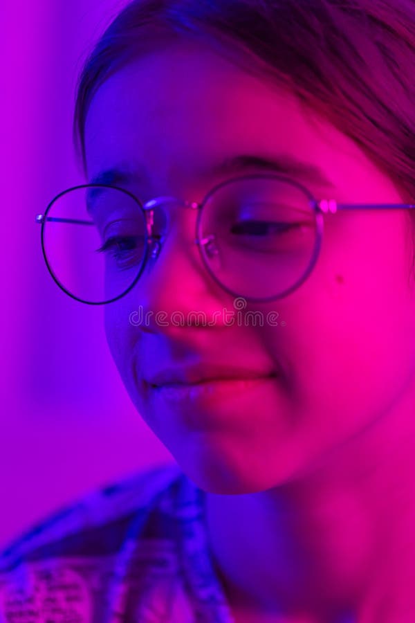Portrait Of A Teenage Girl With Glasses In Neon Light Stock Image