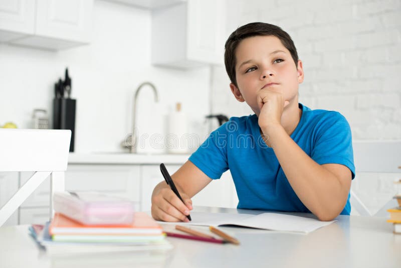 Portrait of Thoughtful Boy Doing Homework Alone at Table Stock Image ...