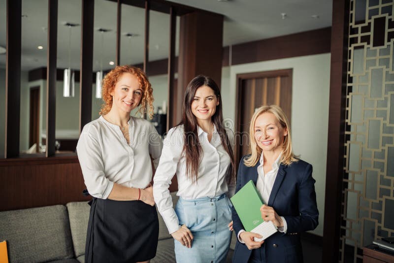 Portrait Of Three Caucasian Business Women In Formal Wear In A Hotel