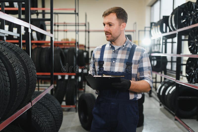 Portrait of a Tire Fitting Worker. a Large Warehouse or Store of ...
