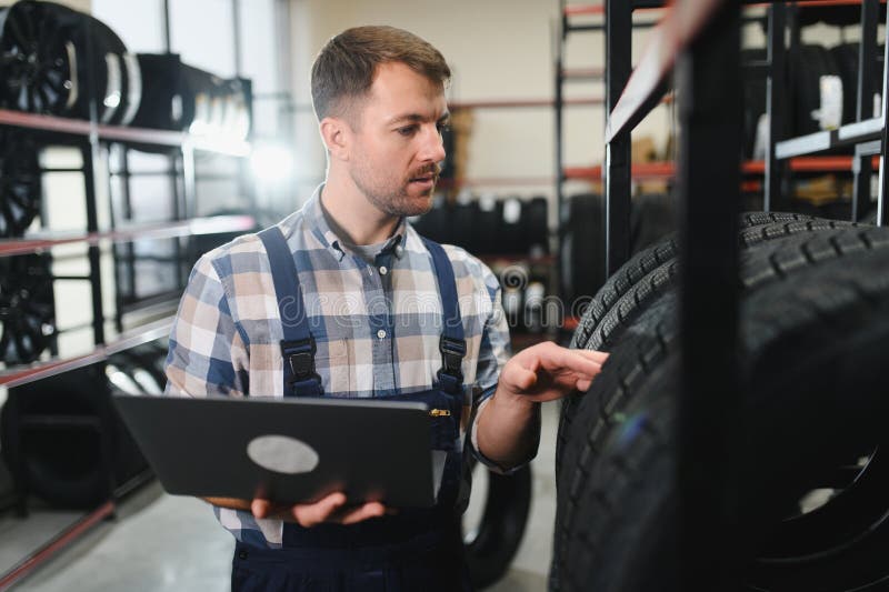 Portrait of a Tire Fitting Worker. a Large Warehouse or Store of ...