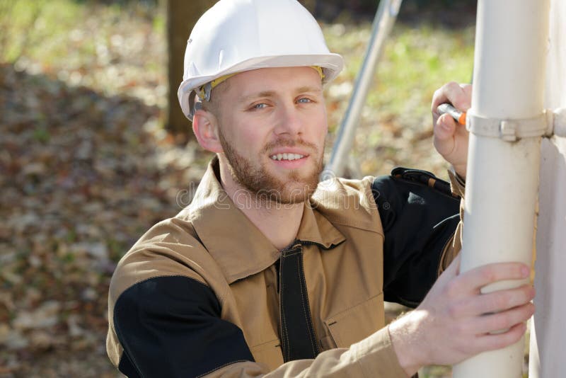 Portrait Tradesman Fixing Downpipe To Exterior Wall Stock Image - Image ...