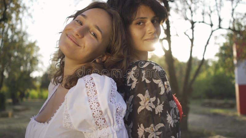 Two Beautiful Lesbian Women Feel Shy Sitting On A Bench And Join Hands