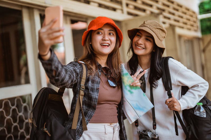 Portrait of Two Backpacker Girls Doing Selfies Using a Mobile Phone ...