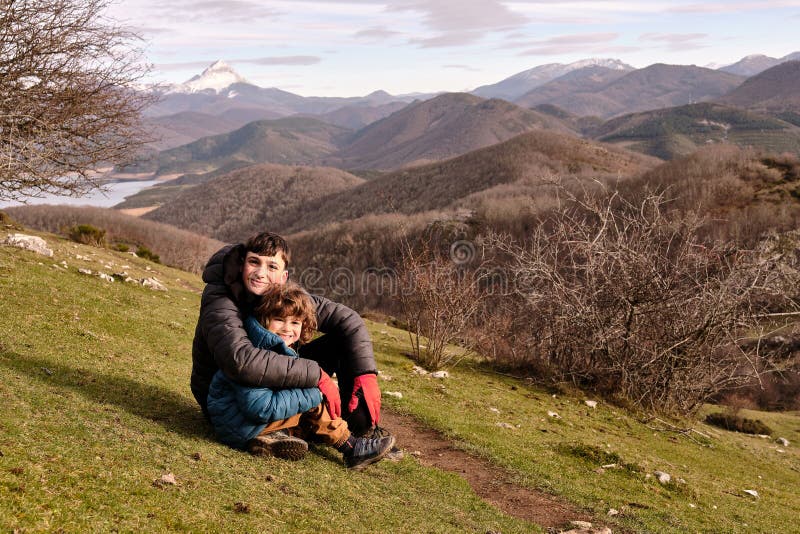 A Portrait of Two Brothers Sitting and Embracing on the Mountain. Stock ...