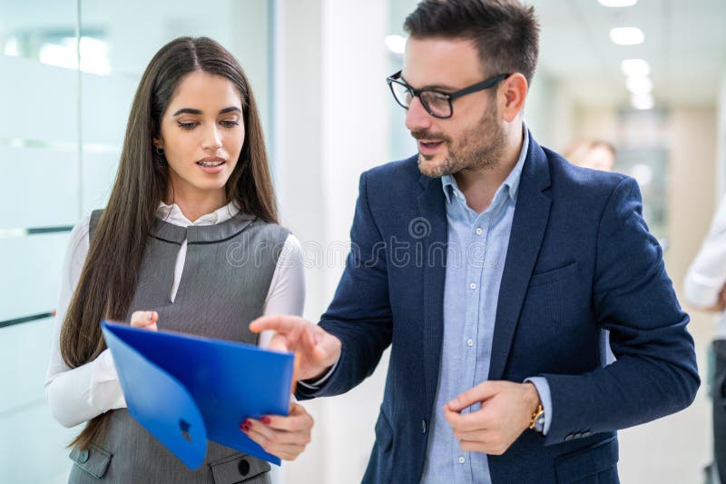 Portrait of Two Business People Commenting Some Paper Documents while ...