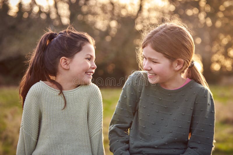 Portrait of Two Girls Outdoors Laughing and Talking Together Stock ...