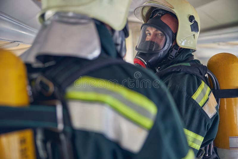 Two Firemen with Full Equipments Standing in the Emergency Place Stock ...