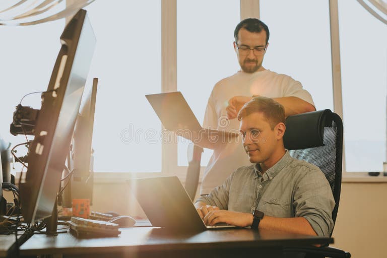 Portrait of Two Professional Male Programmers Working on Computer in Diverse Offices. Modern it ...