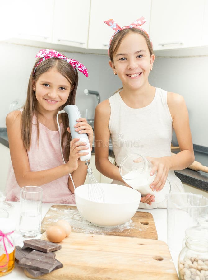 Portrait of Two Smiling Girls Cooking and Making Dough Stock Photo ...