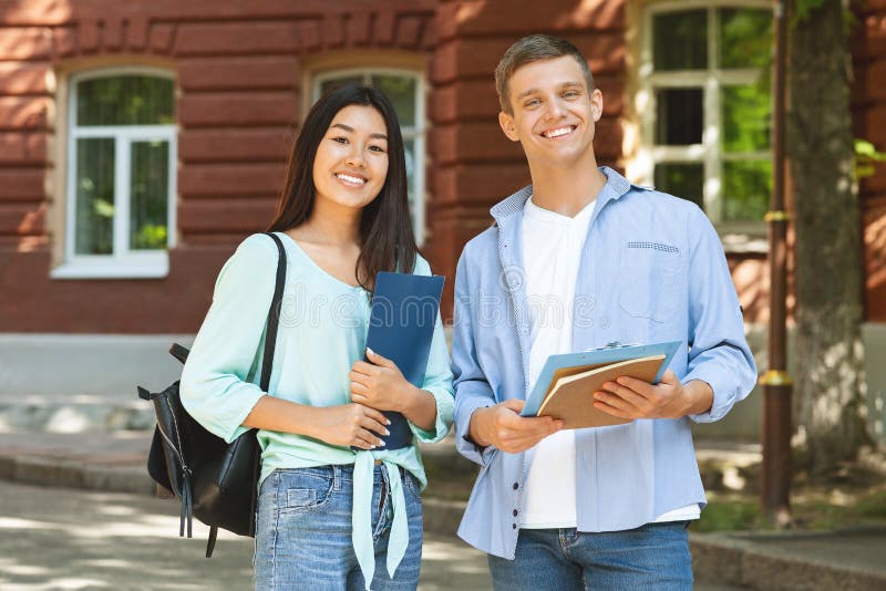 Cheerful College Students Walking Out of Campus Together, Posing ...