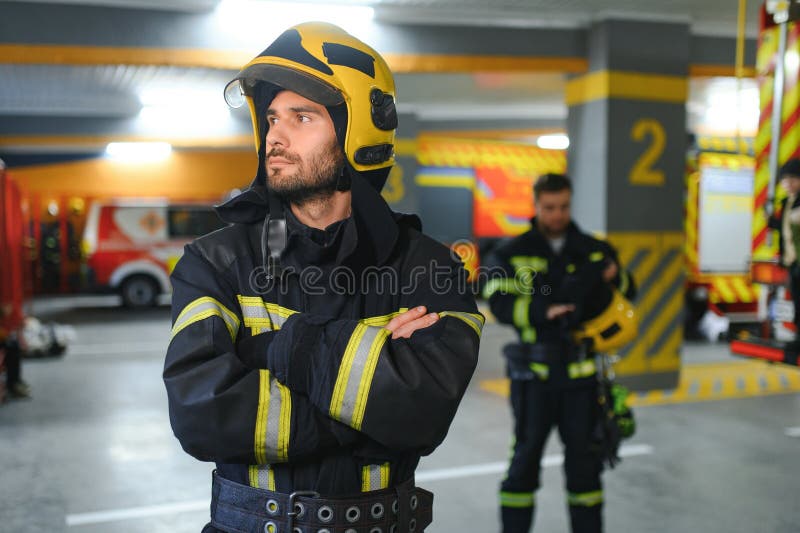 Portrait of Two Young Firemen in Uniform Standing Inside the Fire ...