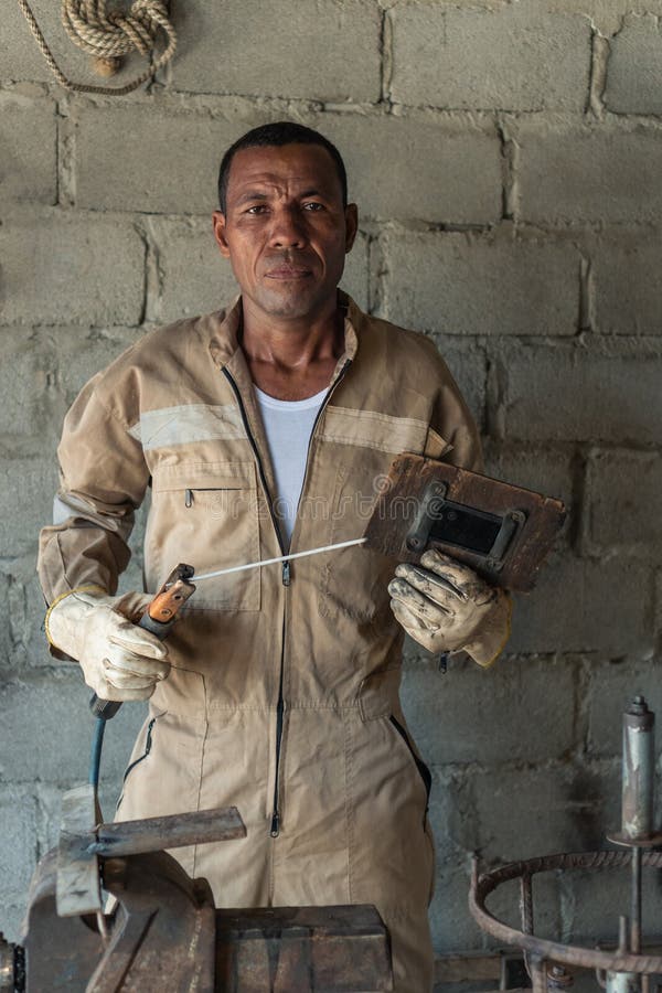 Welder with a Face Shield Using a Welding Machine Stock Photo - Image ...