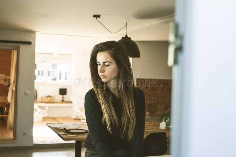Portrait of a Woman Sitting in the Kitchen. Woman Looking Sideways at ...
