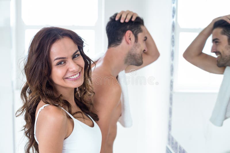 Portrait of Woman Smiling while Man Looking in Mirror Stock Photo ... Portrait of Woman Smiling while Man Looking in Mirror Stock Photo ...