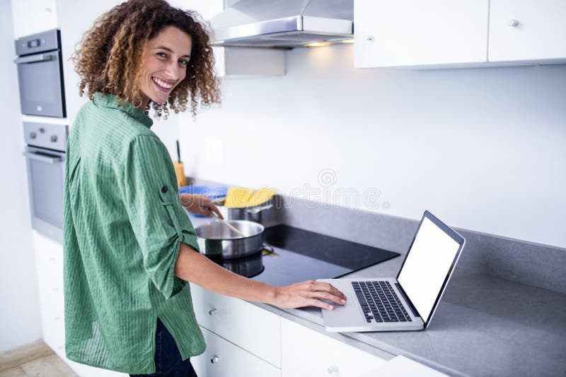 Portrait of Woman Working on Laptop while Cooking Stock Image - Image ...