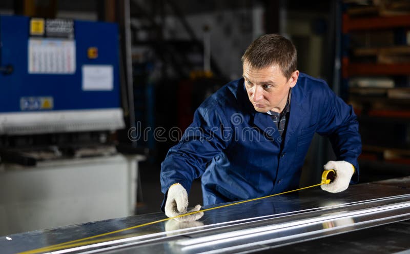 Portrait of Worker with Tape Measure Who Measures Sheet of Iron Using ...