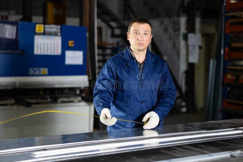 Portrait of Worker with Tape Measure Who Measures Sheet of Iron Using ...