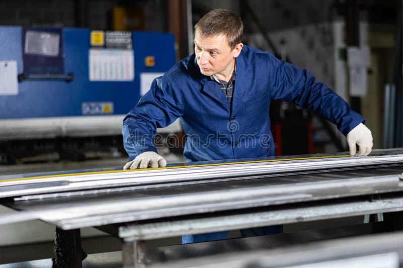 Portrait of Worker with Tape Measure Who Measures Sheet of Iron Using ...