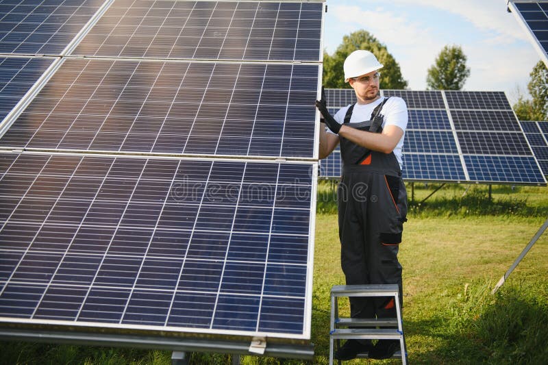 Portrait of a Worker in Uniform and White Helmet Working on Solar ...